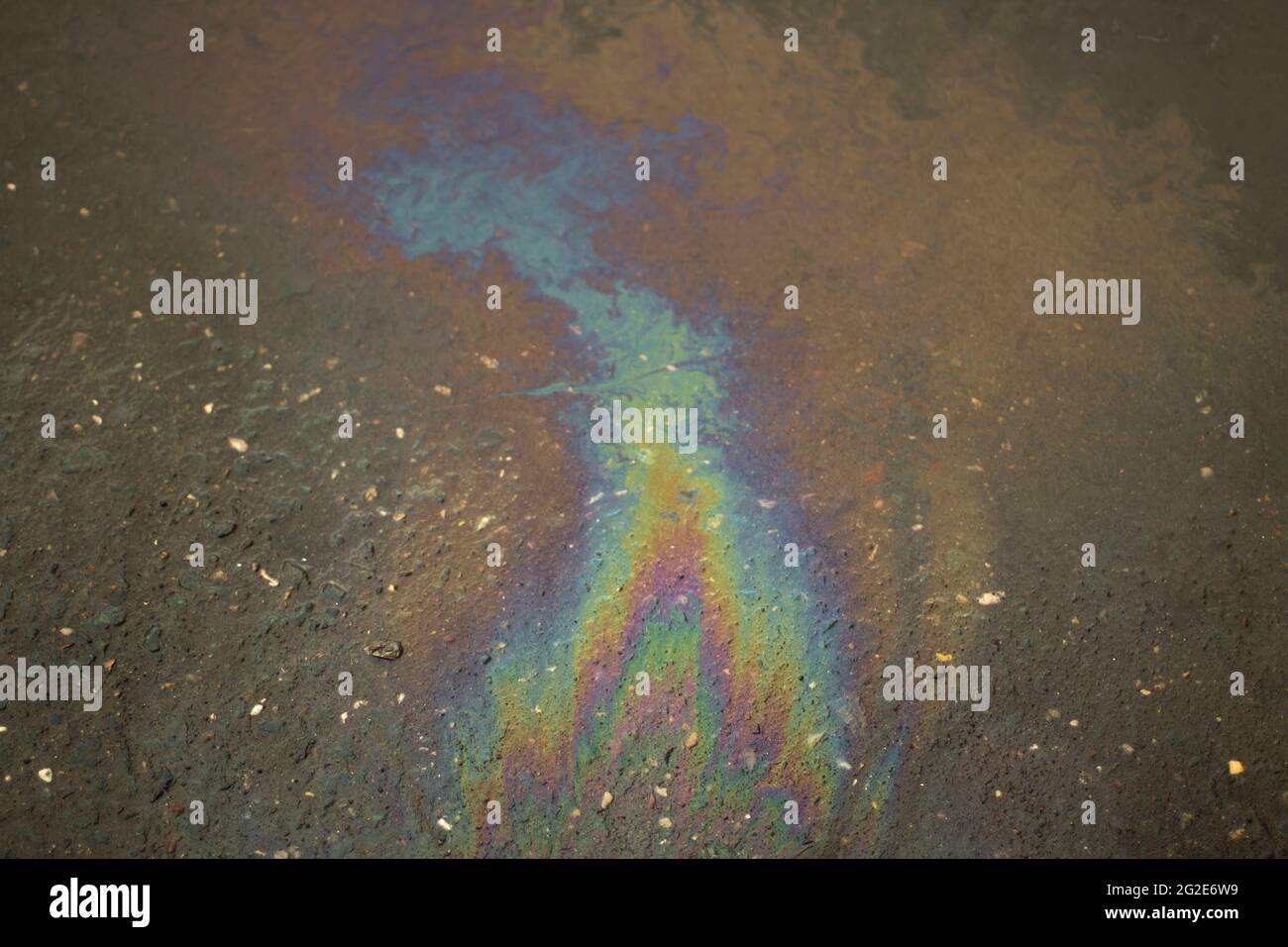 Gasoline on the asphalt. The texture of the fuel spilled on the road ...