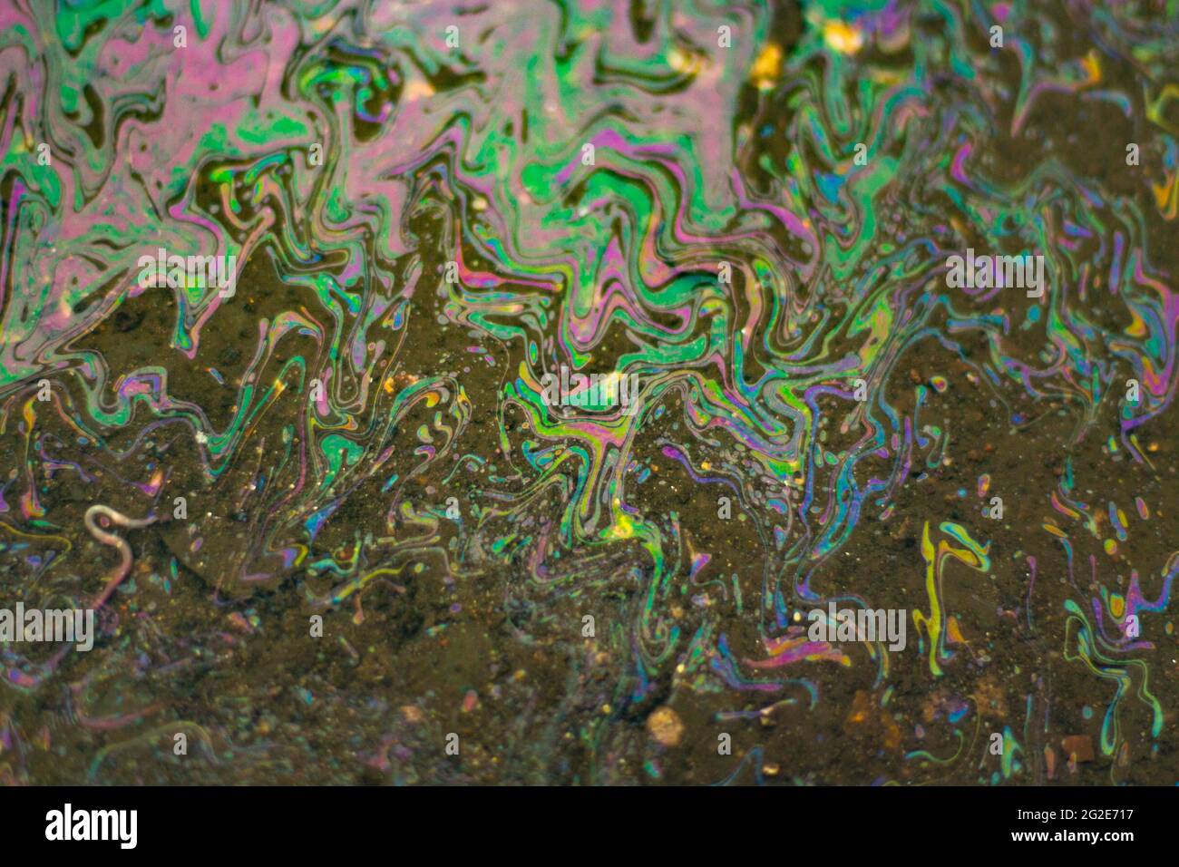 Gasoline on the asphalt. The texture of the fuel spilled on the road ...