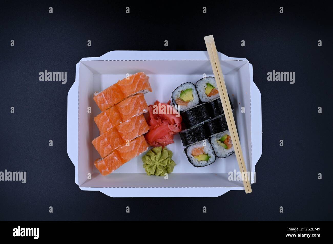 Sushi sets with red ginger and wasabi in a takeaway box. Isolated black ...