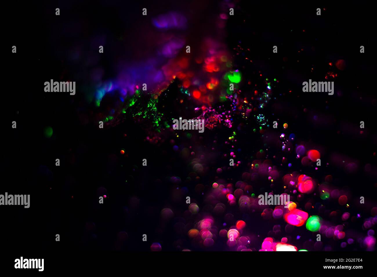 Colored water texture. Splashes of water lit in different colors. Close ...