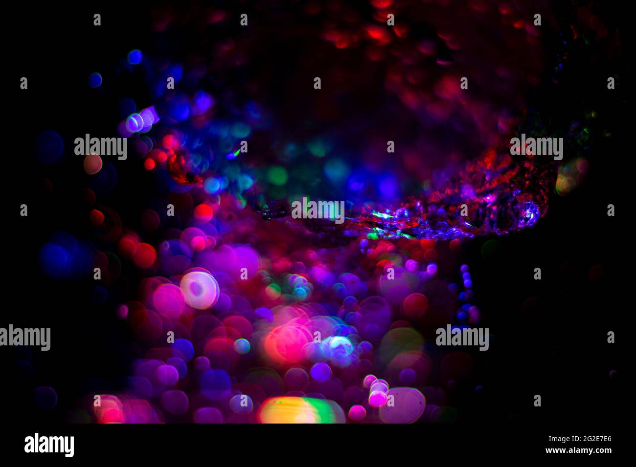 Colored water texture. Splashes of water lit in different colors. Close ...