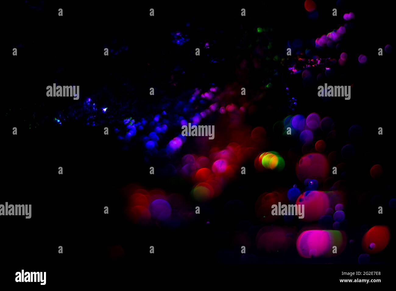 Colored water texture. Splashes of water lit in different colors. Close ...