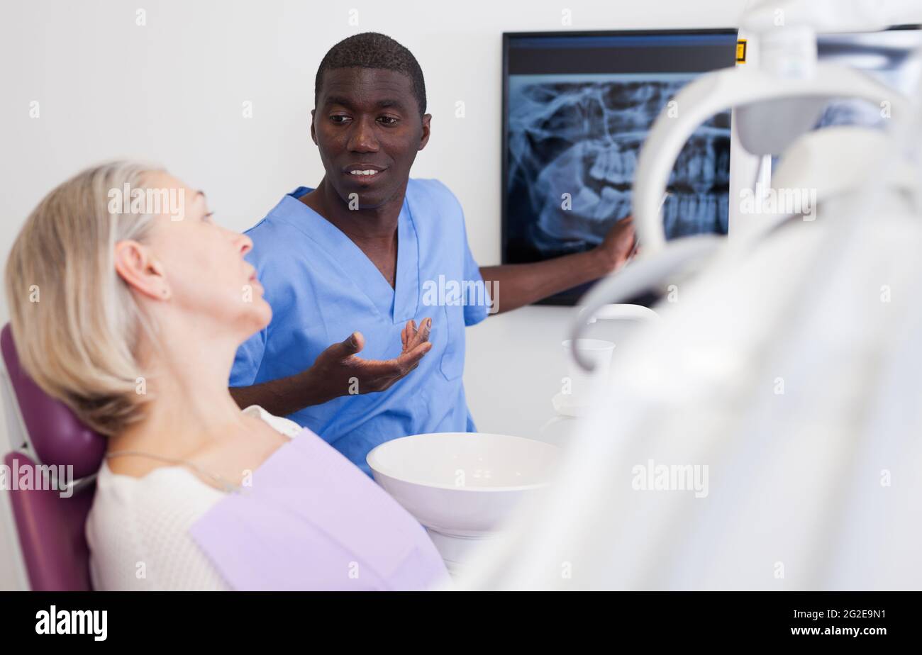 African american doctor man shows the patient an x-ray Stock Photo - Alamy
