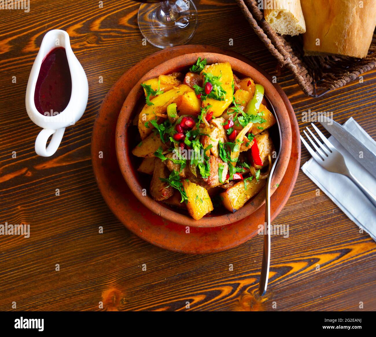 Traditional georgian Ojakhuri with pomegranate in earthenware ketsi pan ...
