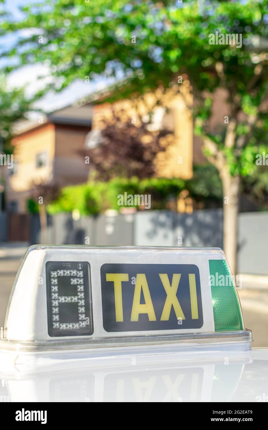 Illuminated "TAXI" sign on a cab parked in front of his house Stock ...