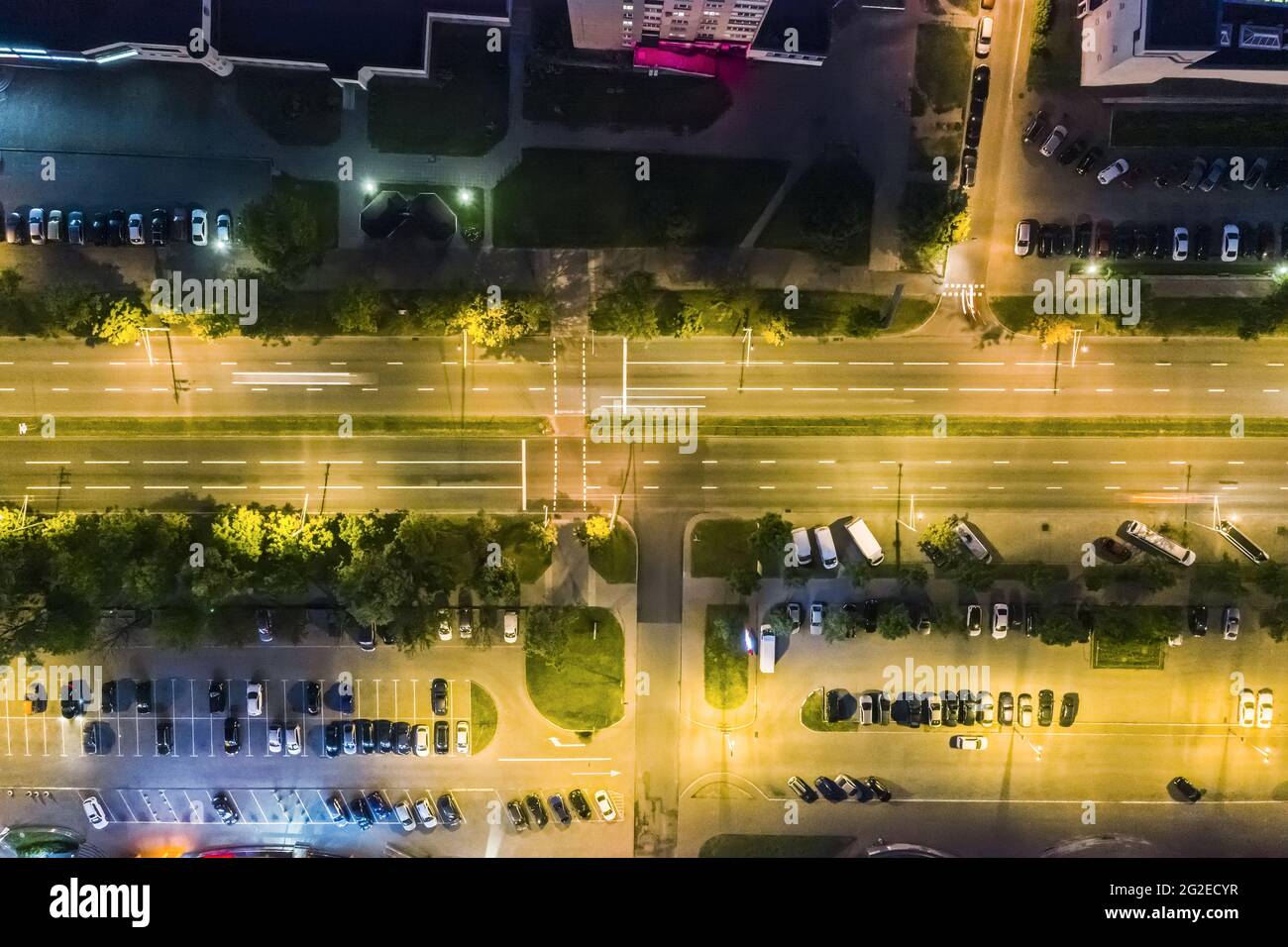 night cityscape with street and parking lot with parked cars. aerial ...