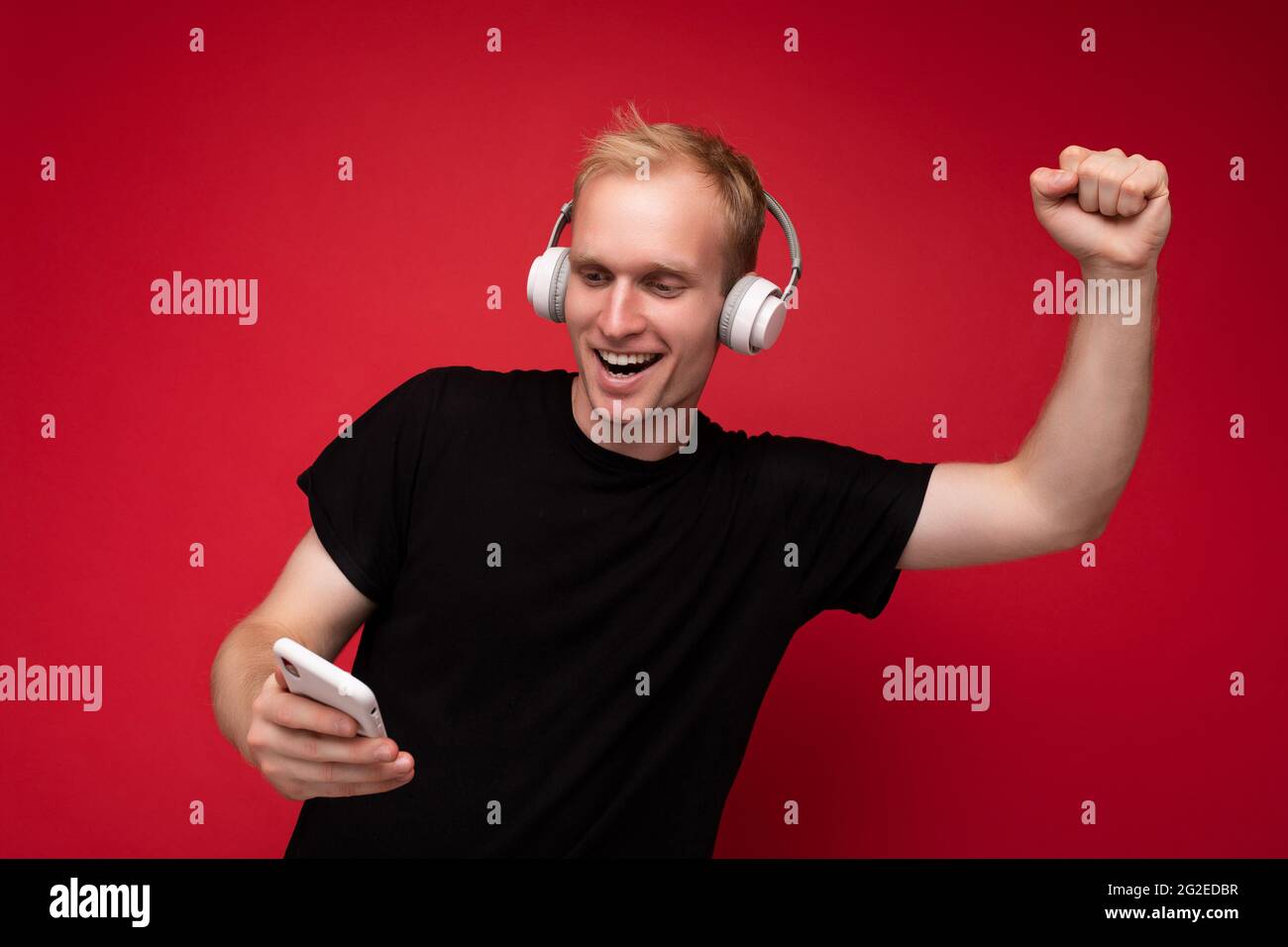 Positive delightful handsome blonde young man wearing black t-shirt and ...