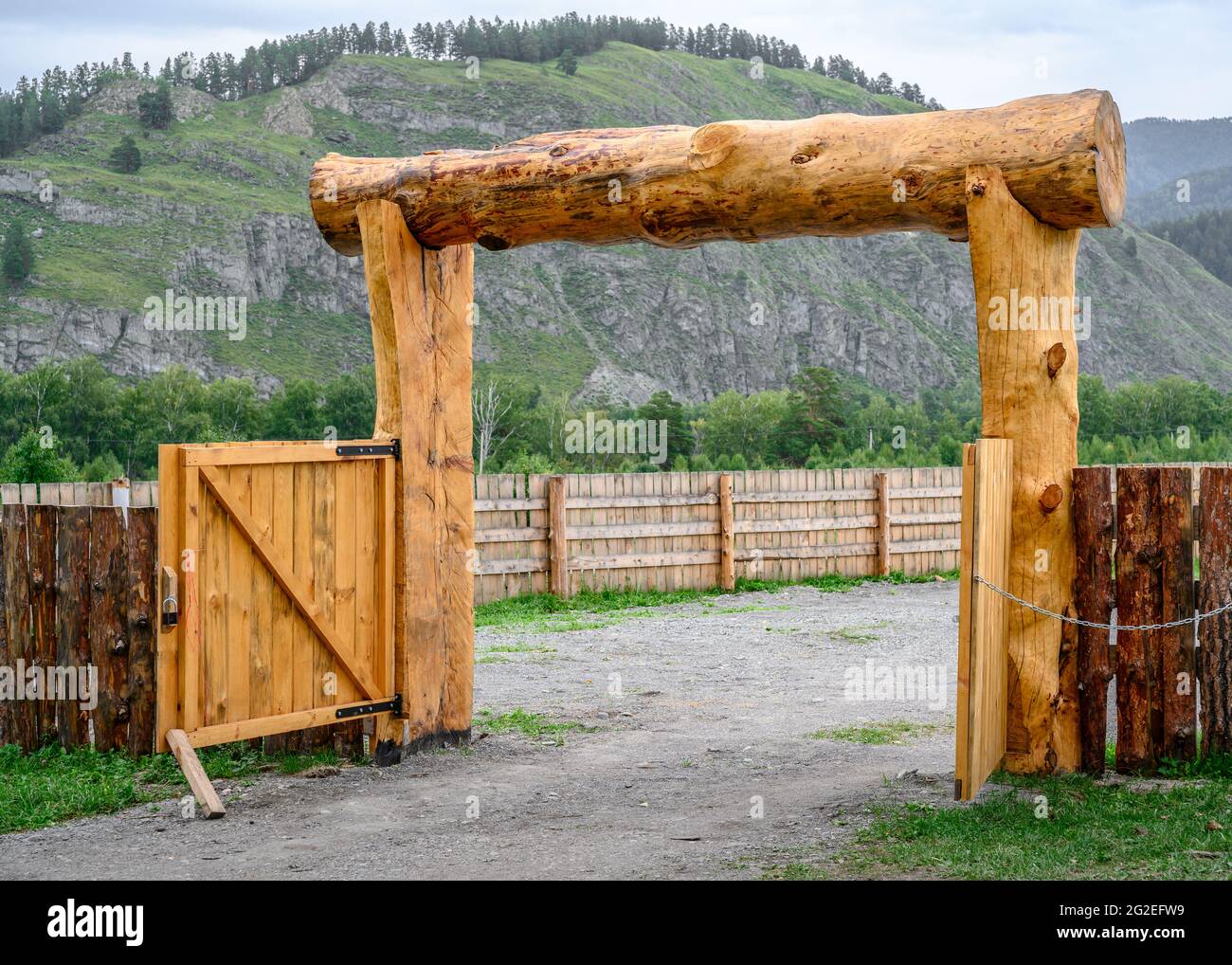 Wooden gate to the village yard made of huge logs against the ...