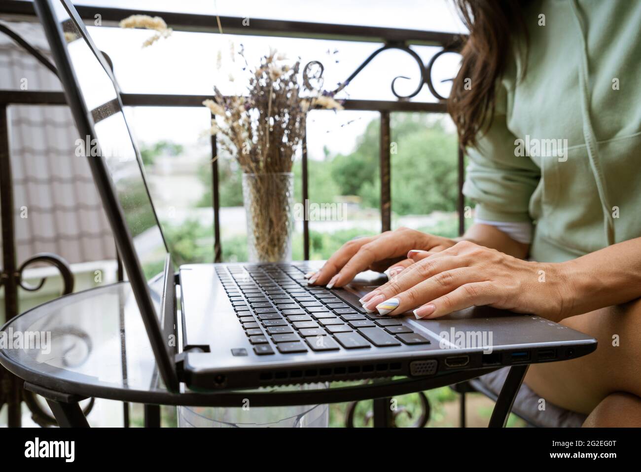 Young woman works at a laptop on the terrace. Remote work concept Stock ...