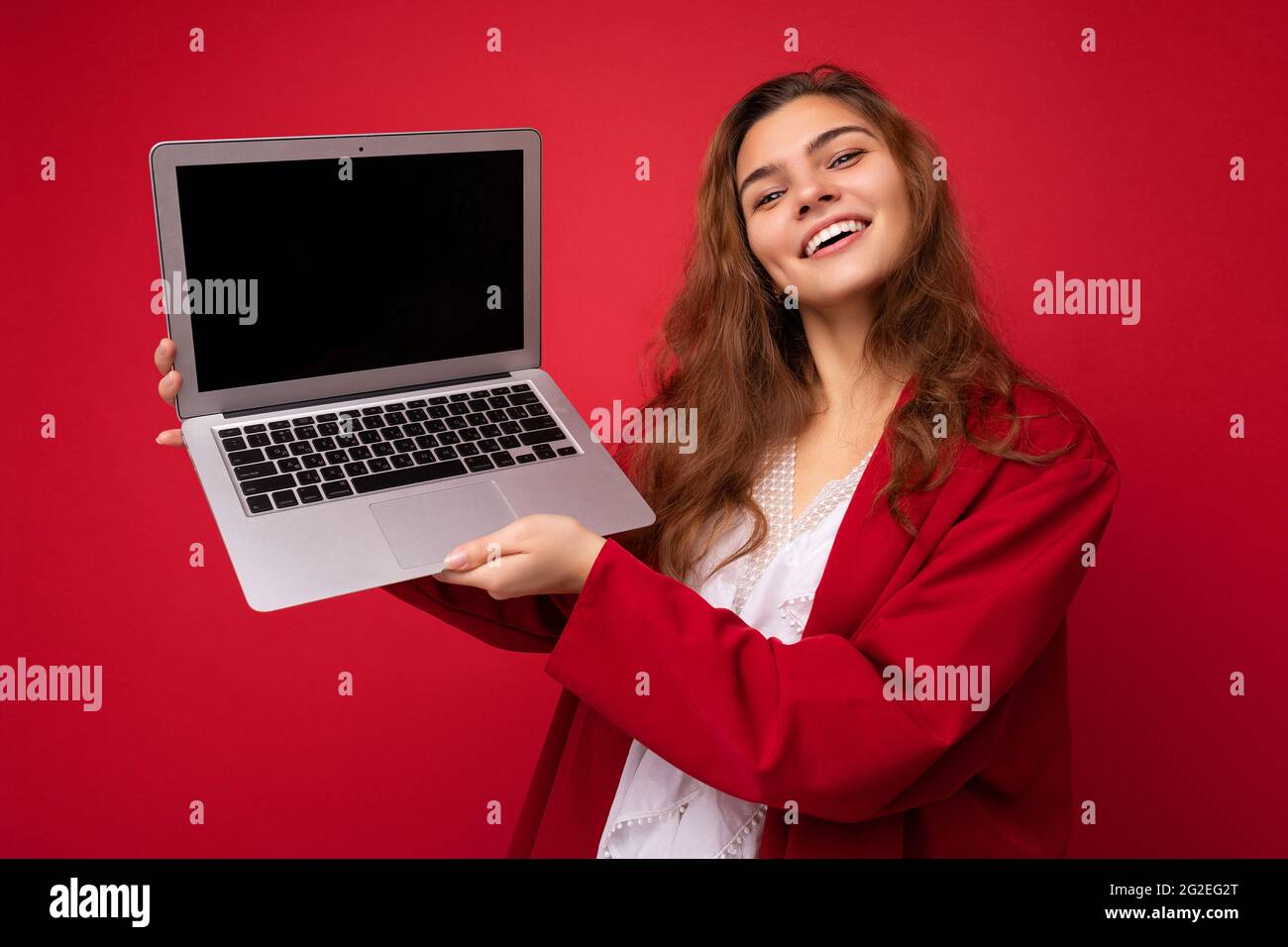 Photo of beautiful young woman holding computer laptop looking at ...