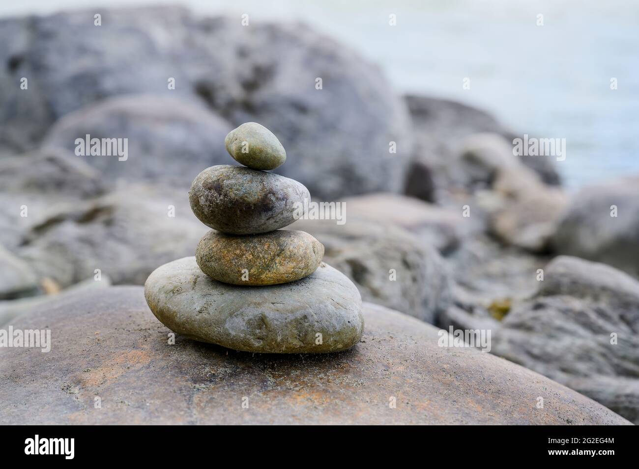 Four stones stacked in a pyramid on the river bank Stock Photo - Alamy