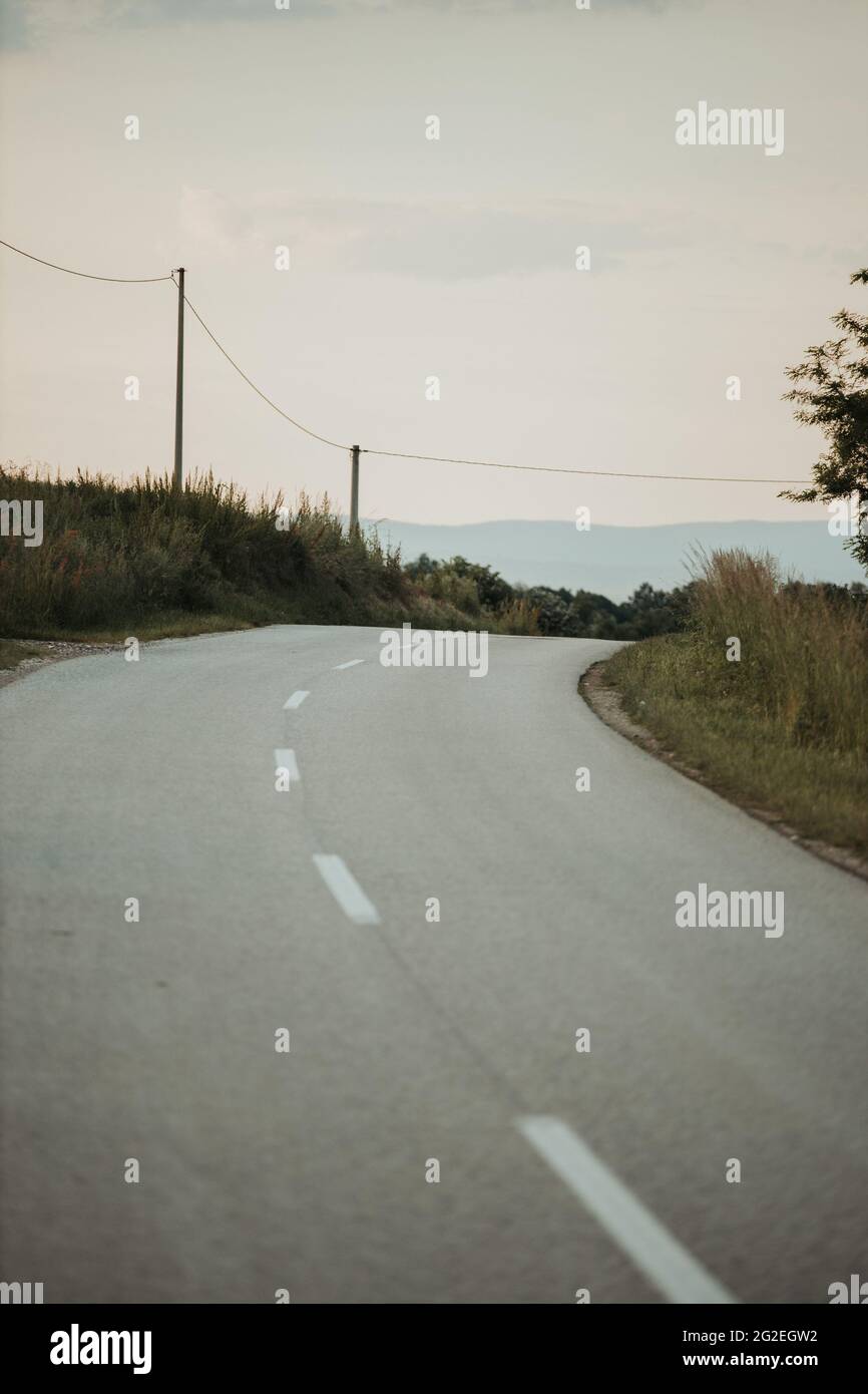 Vertical shot of an empty rural street from a fast-traveling car during ...