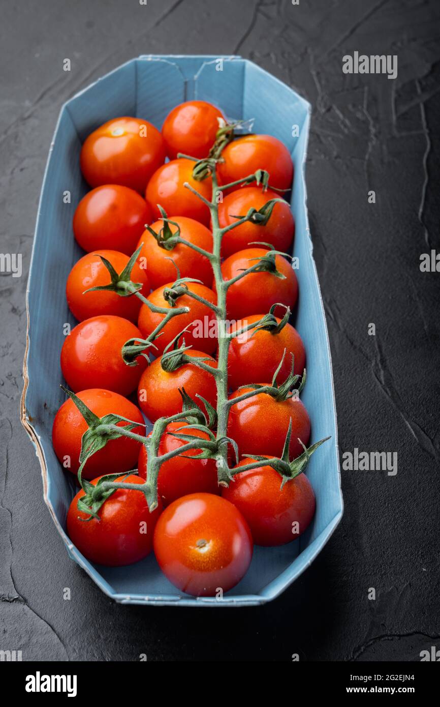 Fresh red organic cherry tomatoes, on black background Stock Photo - Alamy