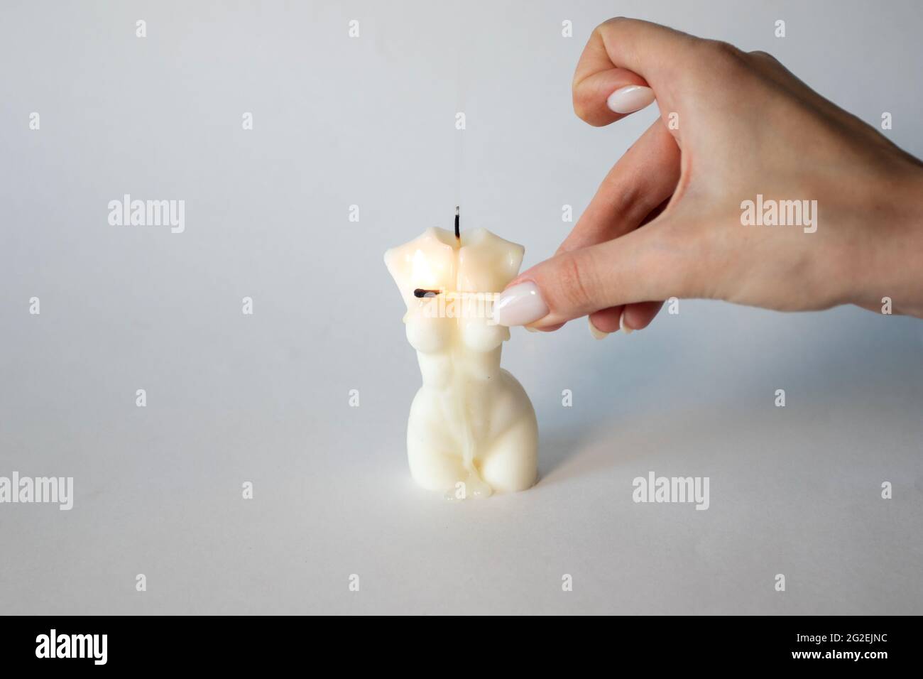A woman hand lighting a scented candle with a match Stock Photo - Alamy