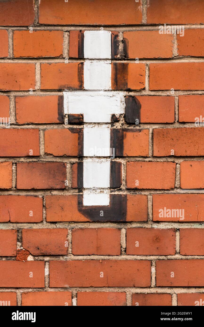 A white letter t painted on a red brick wall Stock Photo - Alamy