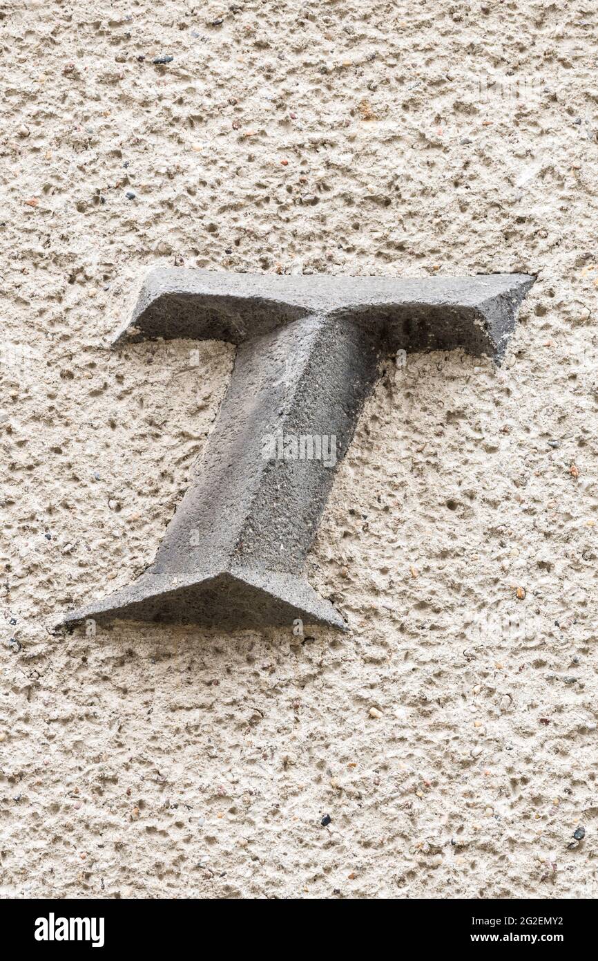 Capital letter T on roughly plastered wall Stock Photo - Alamy