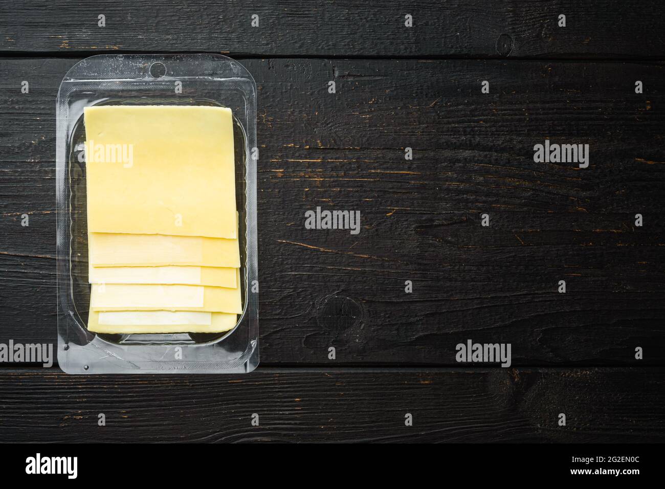 Sliced delicious edam cheese set, in plastic pack, on black wooden ...
