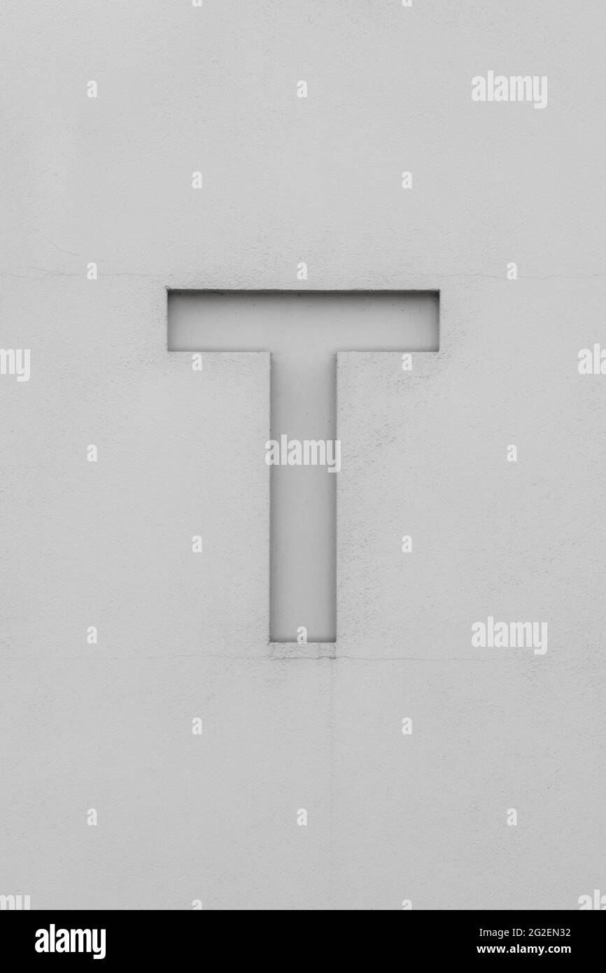 Capital letter T negative relief in gray concrete Stock Photo - Alamy