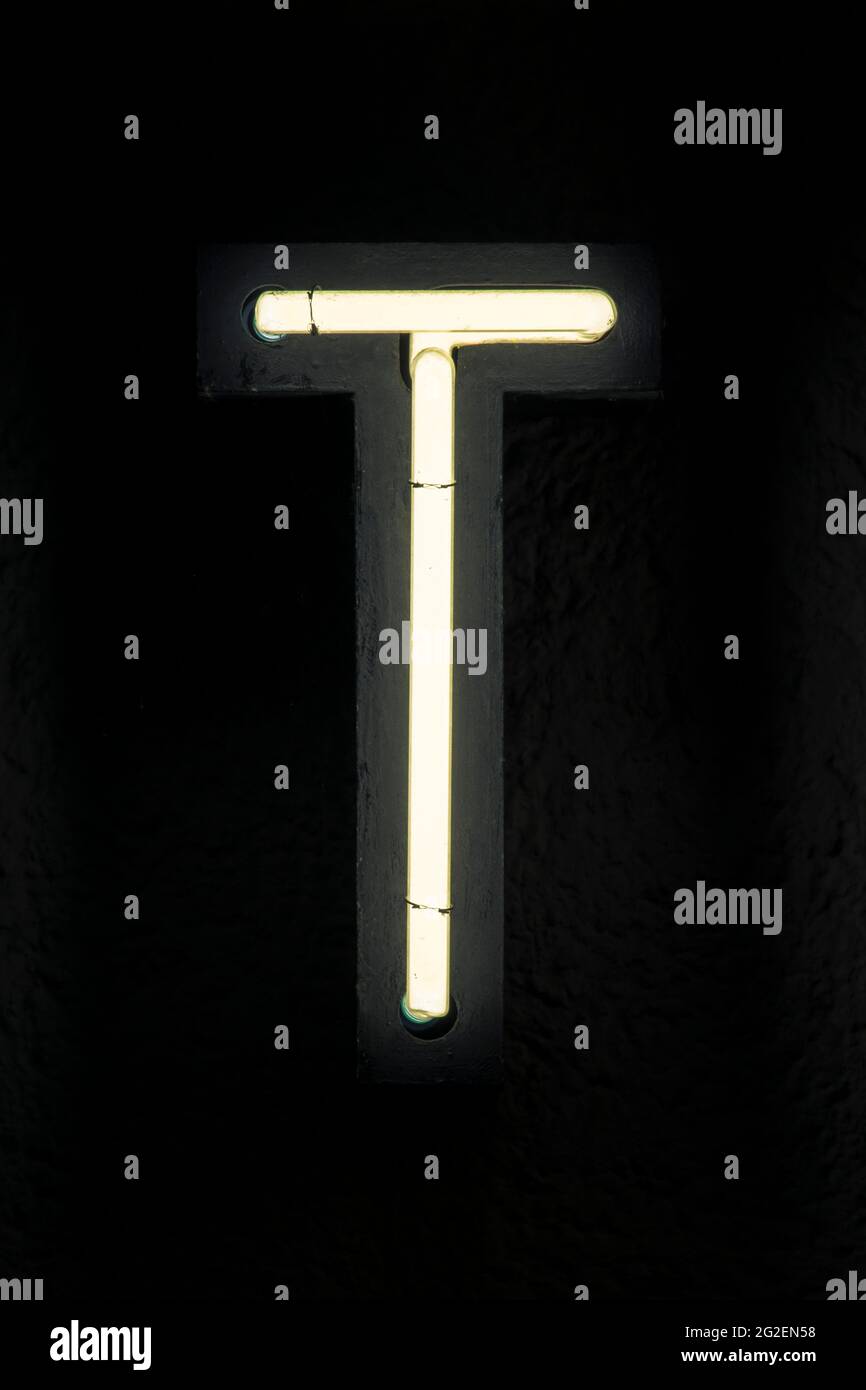 White neon letter T glowing in the dark in the dark Stock Photo - Alamy