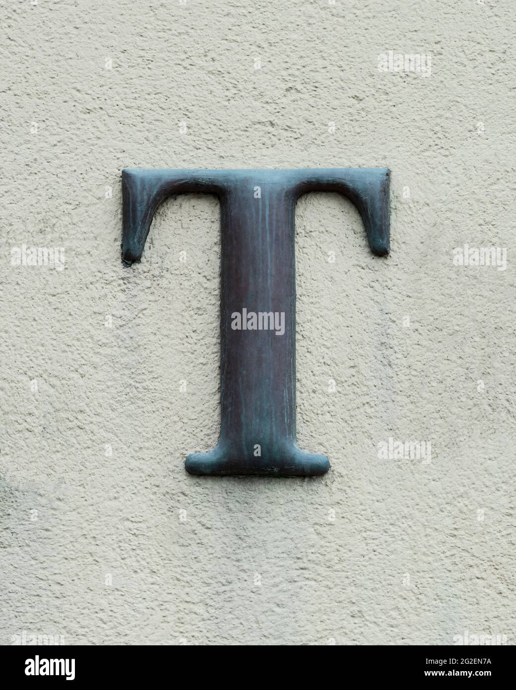 Metal letter T on a house wall Stock Photo - Alamy