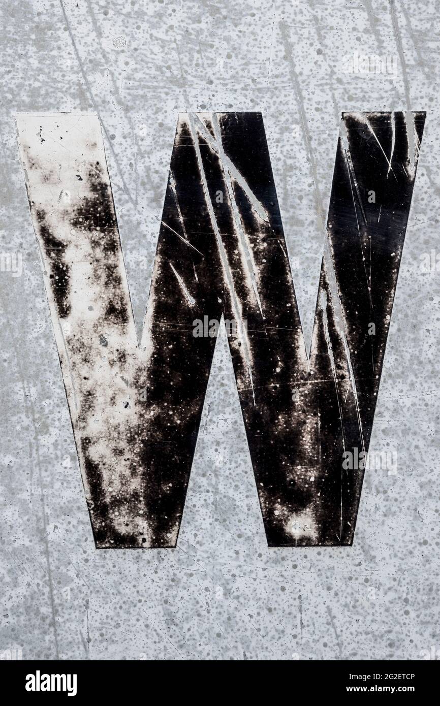 Weathered black letter W of a signpost Stock Photo - Alamy