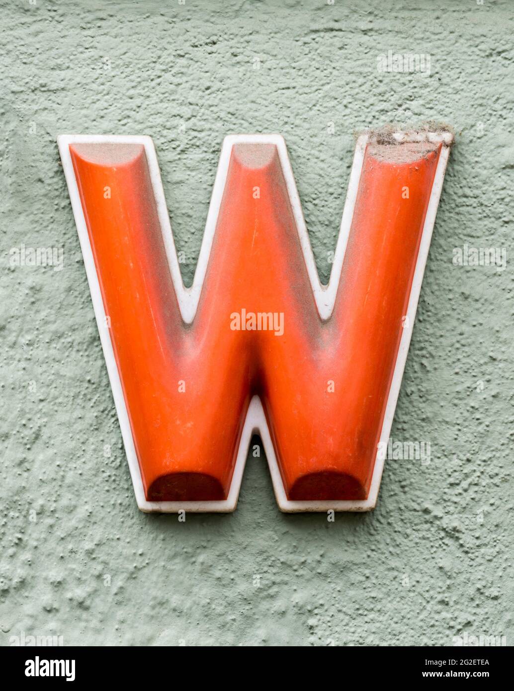 Orange letter W with white outline against light green background Stock ...