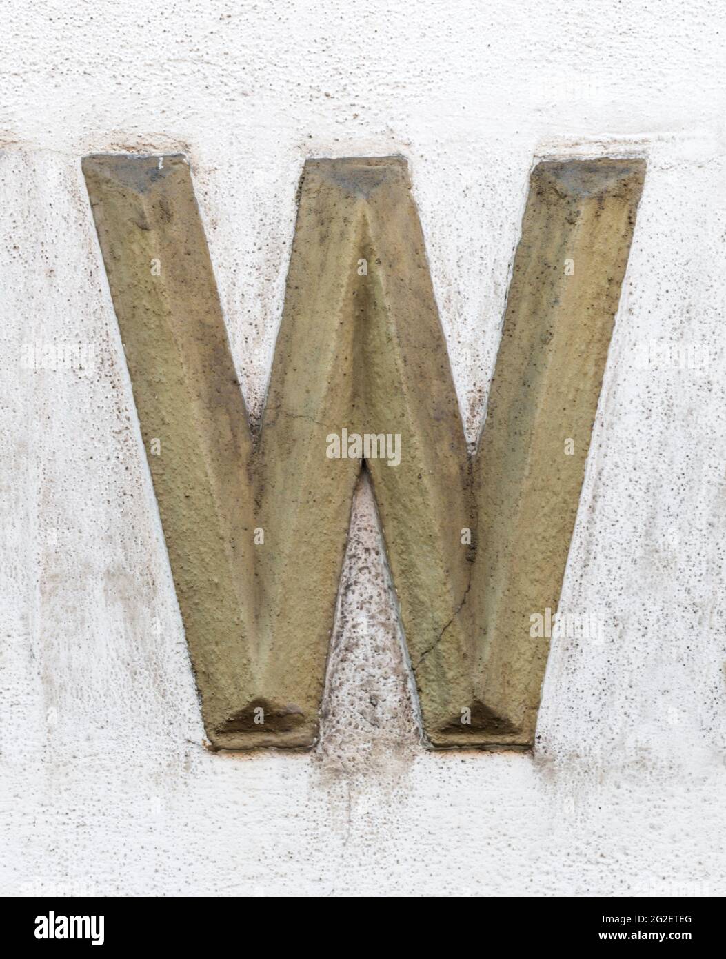 Olive green stucco capital letter W Stock Photo - Alamy