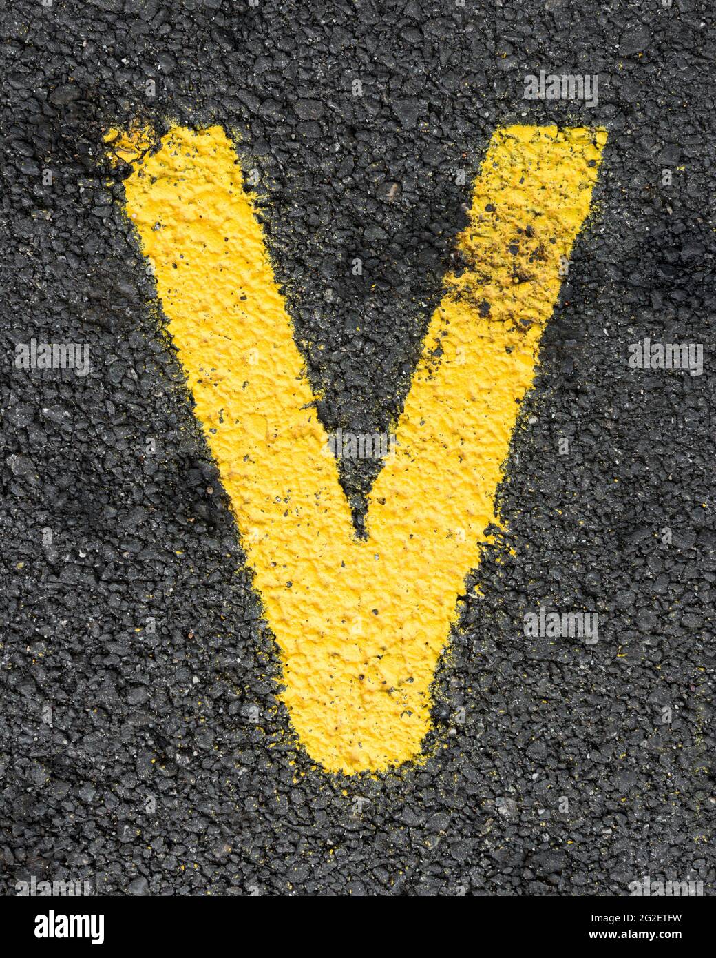 Yellow letter V painted on asphalt Stock Photo - Alamy