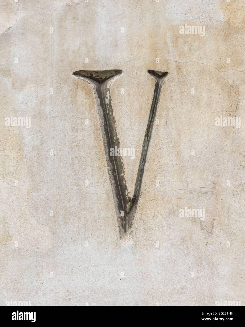 Letter V carved in stone Stock Photo - Alamy