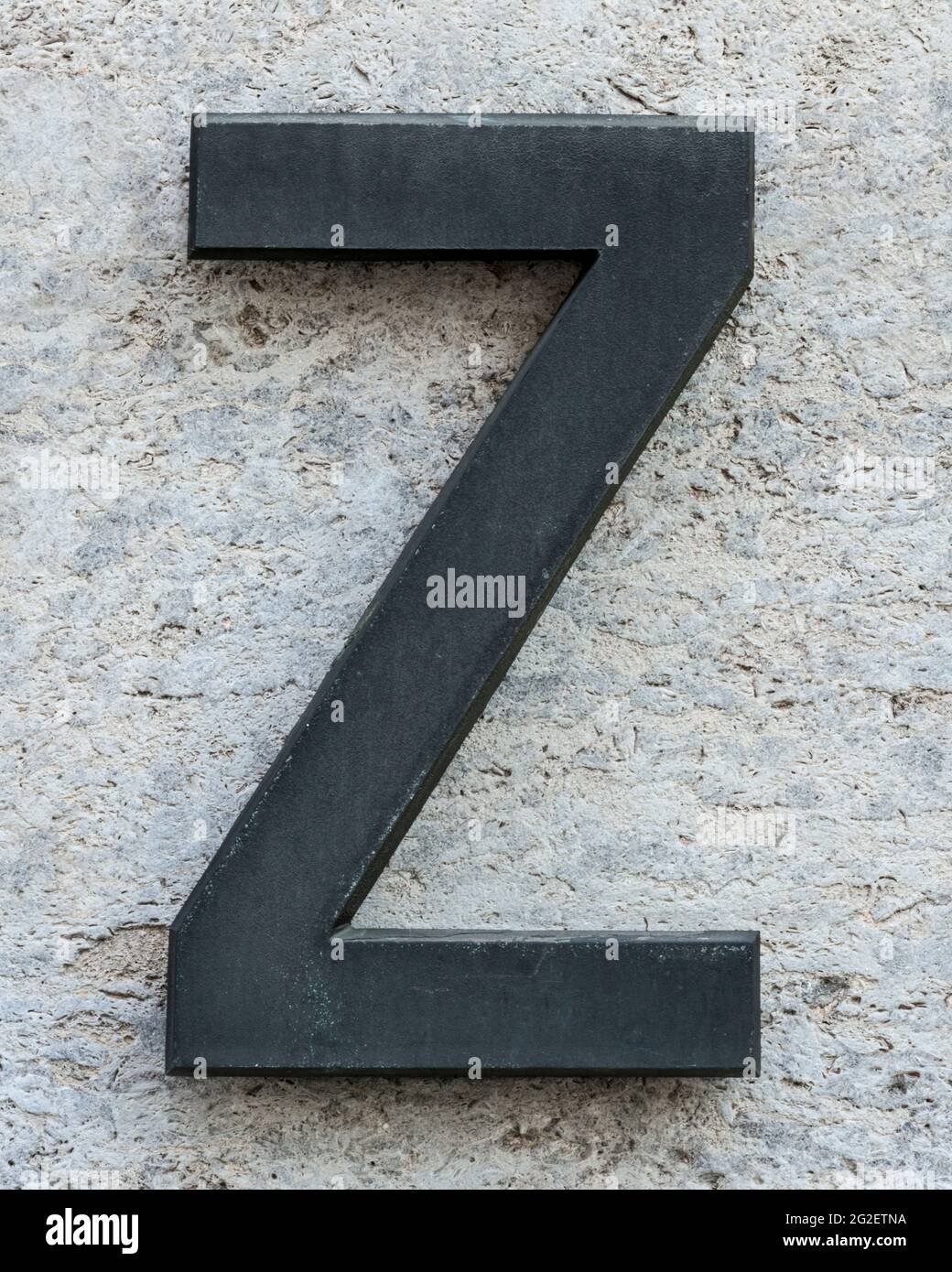 Metal letter in dark gray on a wall Stock Photo - Alamy
