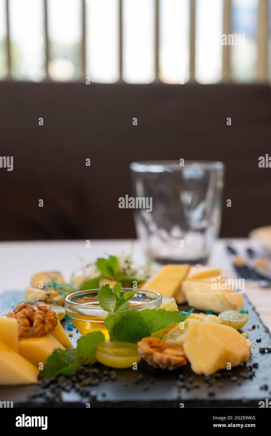 Assorted snacks on a black stone plate on a restaurant table on a ...