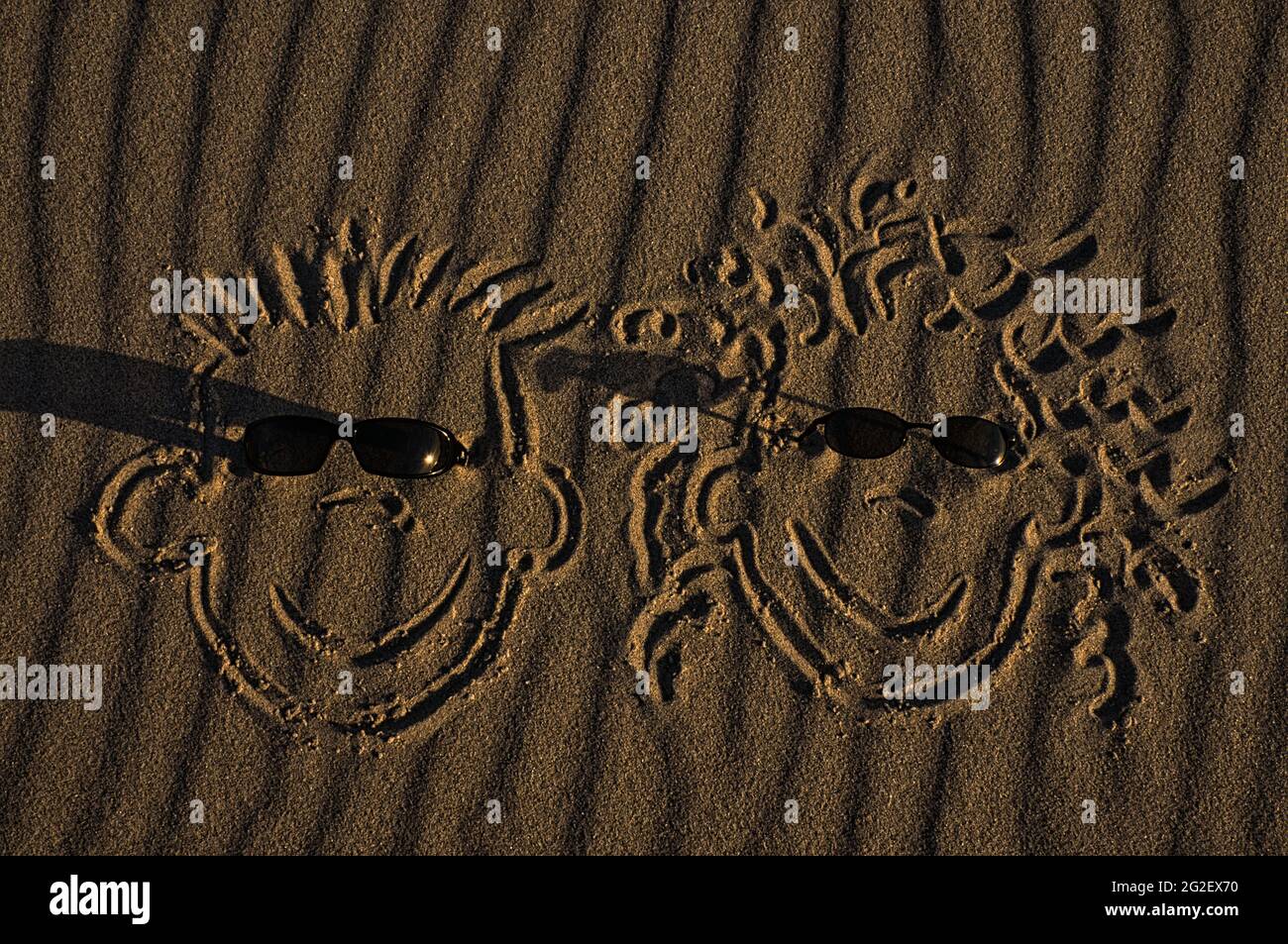 Drawn faces in the sand on the beach near Zingst at sunset Stock Photo ...