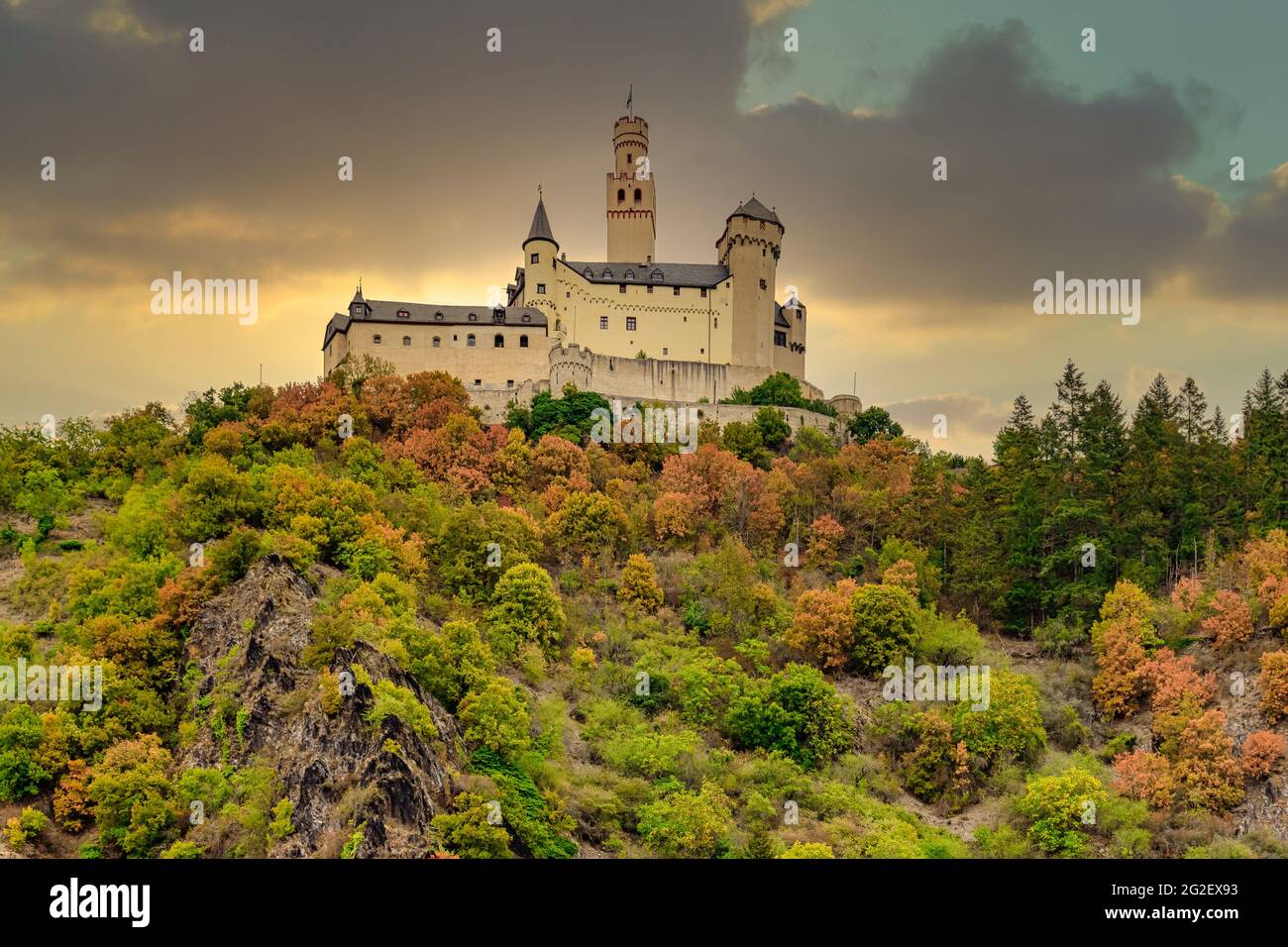 Low angle shot of Marksburg Castle on top of a hill with colorful trees ...