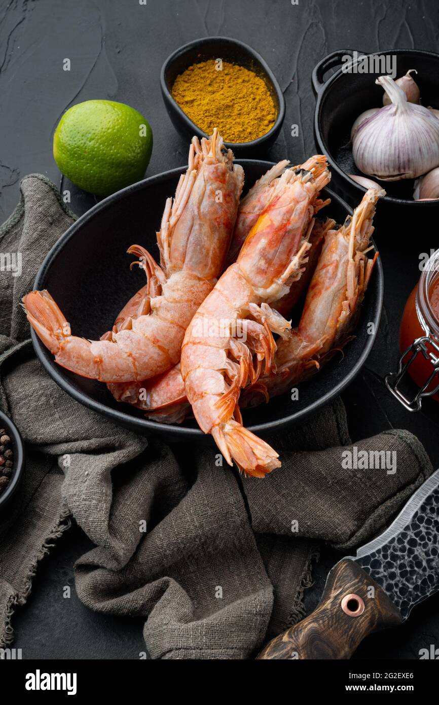Raw king prawns or shrimps set in bowl, on black background Stock Photo ...