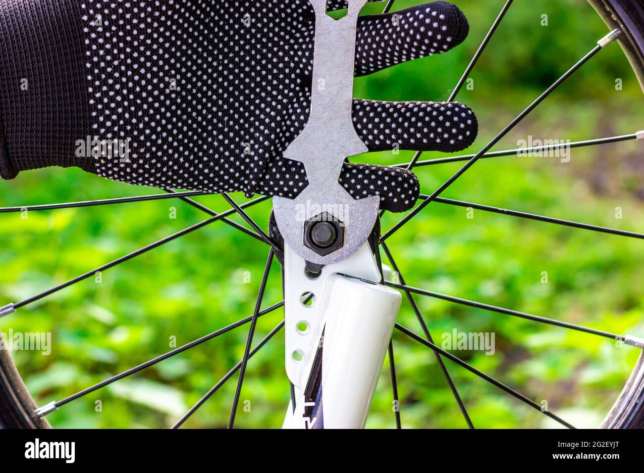 Bicycle key in hand. Tightening the nut on the bicycle wheel ...