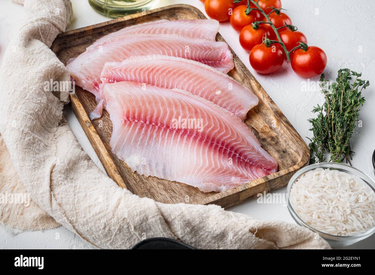 Raw white fish tilapia, with basmati rice and cherry tomatoes ...