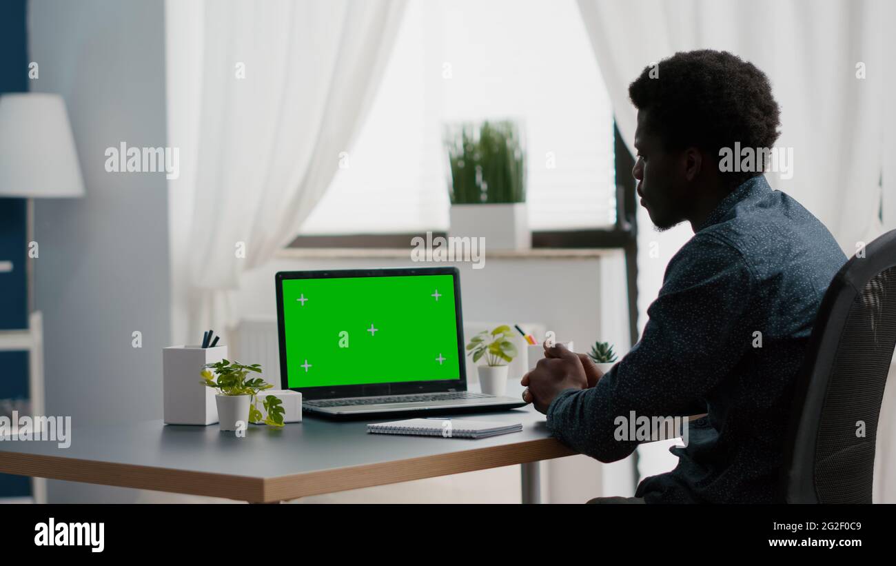 African american man using mockup laptop with green screen. Computer ...