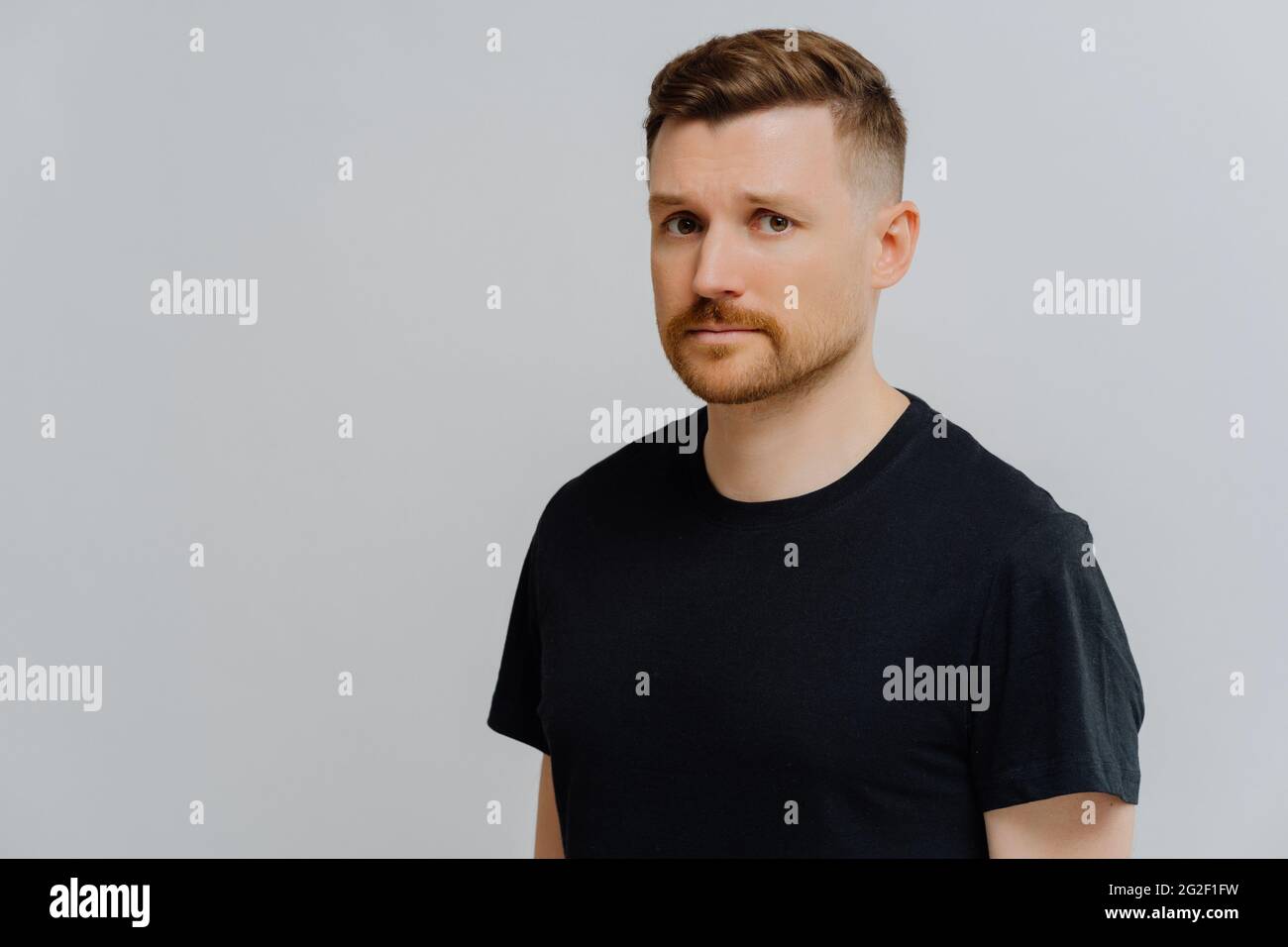 Young ginger man feeling sad and disappointed, looking at camera with ...