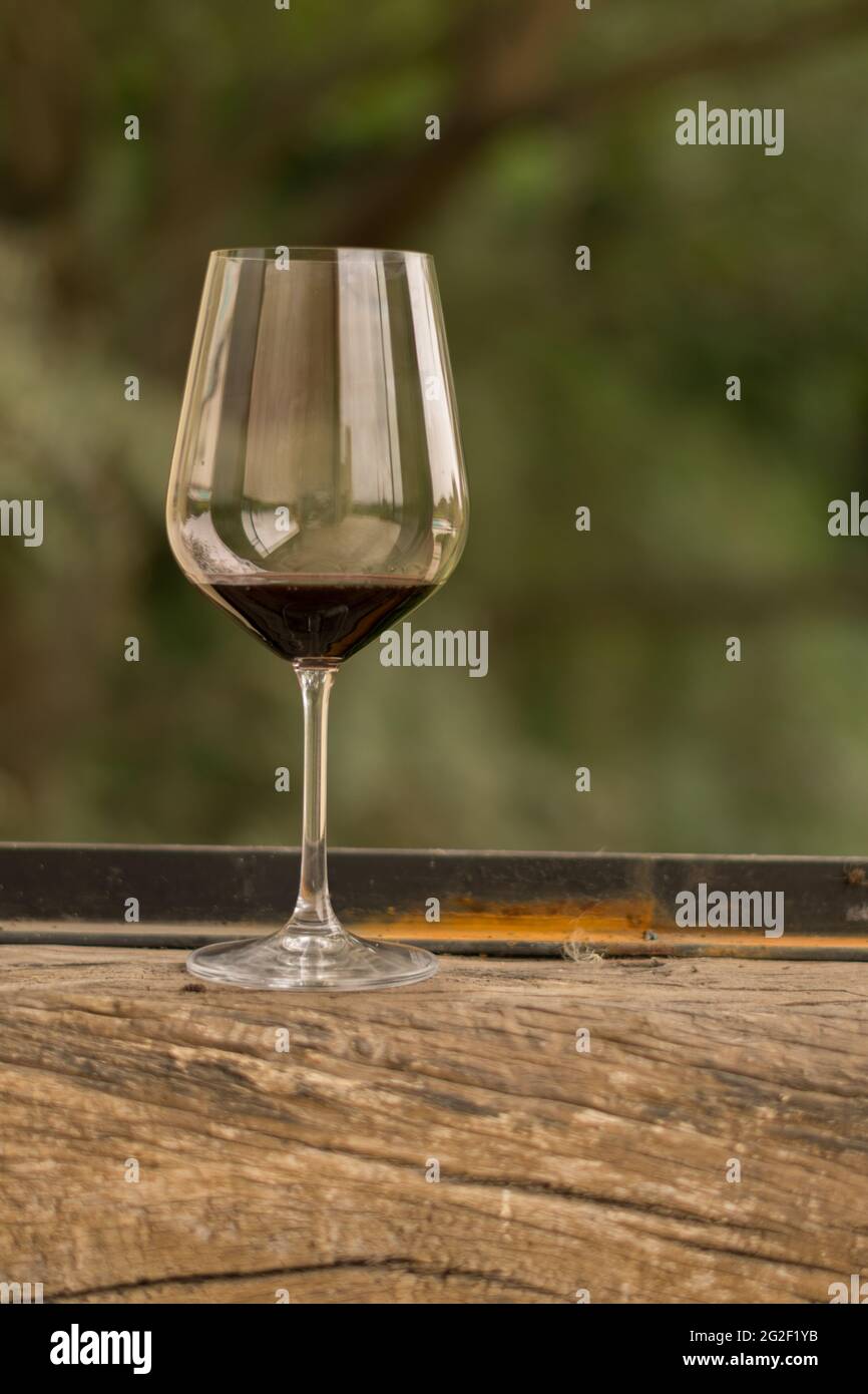 Almost empty glass of red wine put on a wooden window sill Stock Photo ...