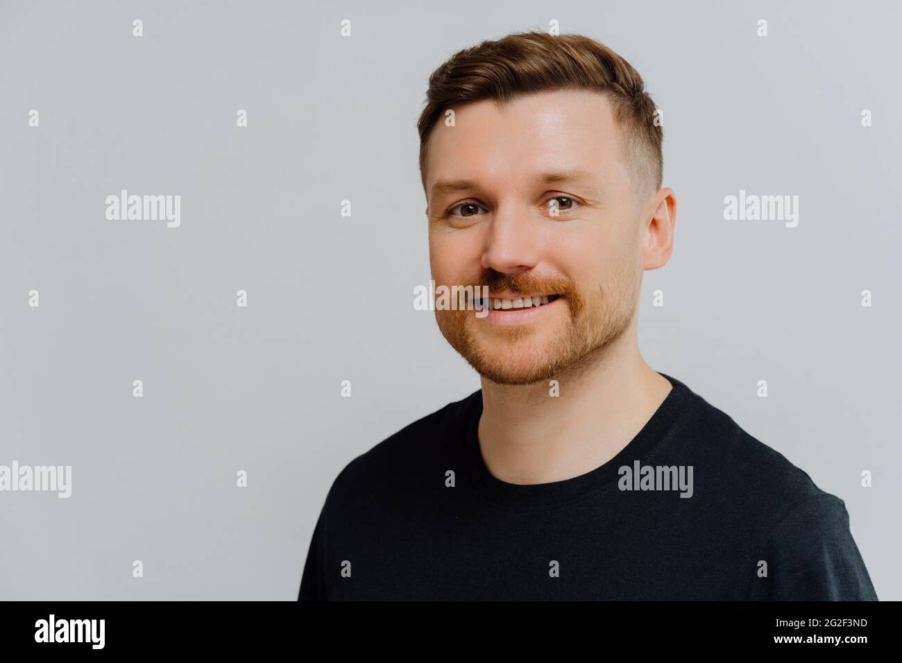 Handsome unshaven man smiling at camera and expressing positivity Stock ...