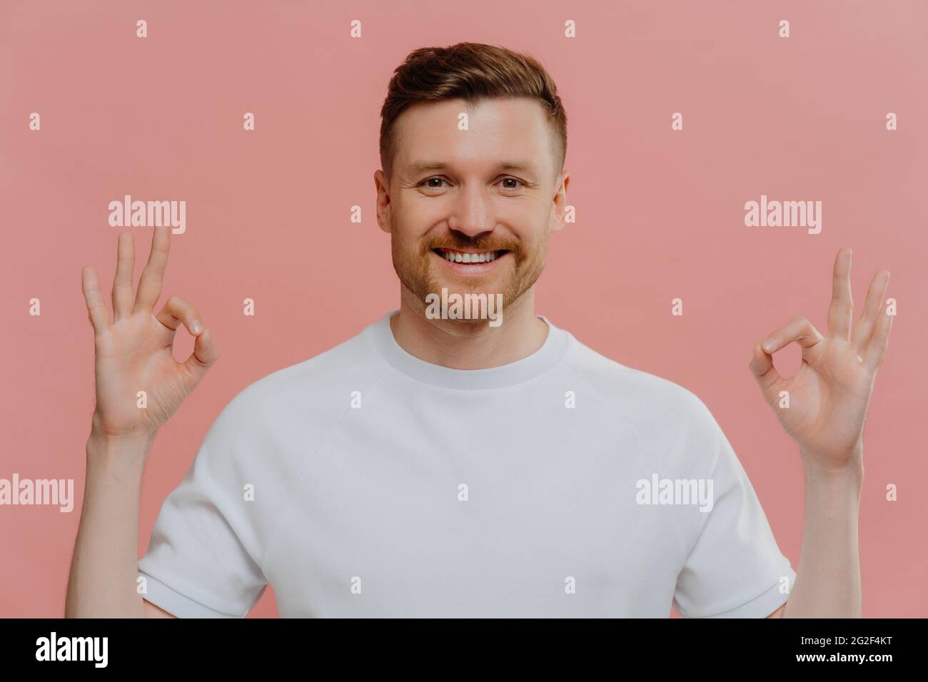 Young happy man showing okay gesture with both hands Stock Photo - Alamy