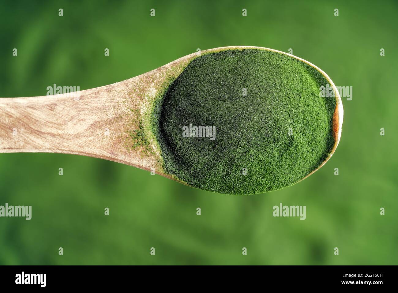 Green chlorella algae powder on a wooden spoon, top view. Healthy ...