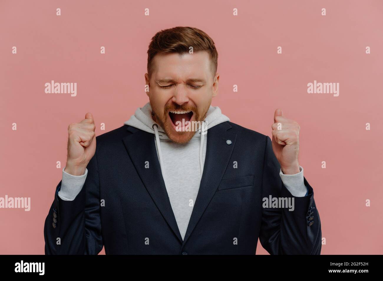 Overjoyed man raising clenched fists and screaming from happiness ...