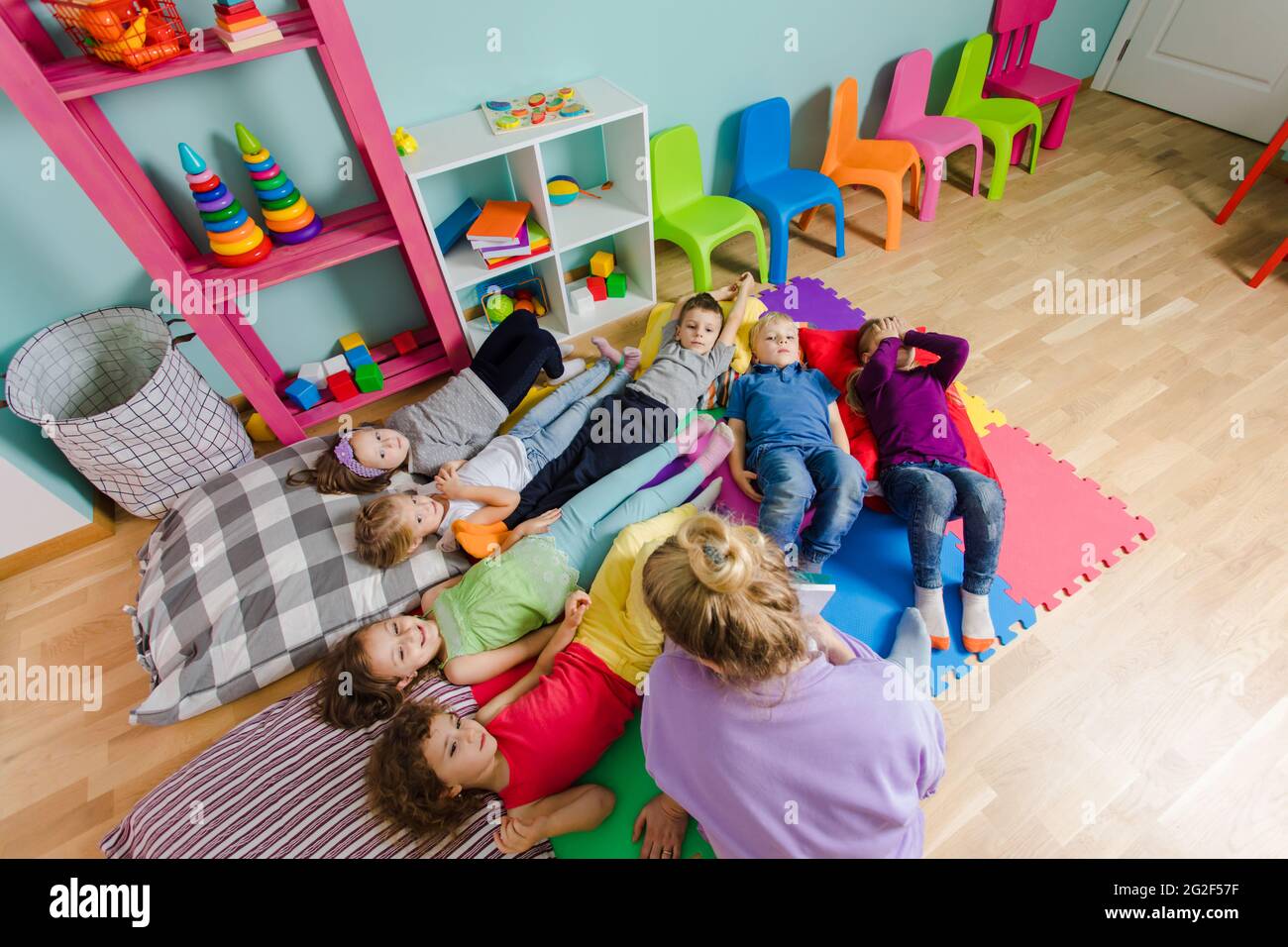 Time for reading stories at the daycare Stock Photo - Alamy