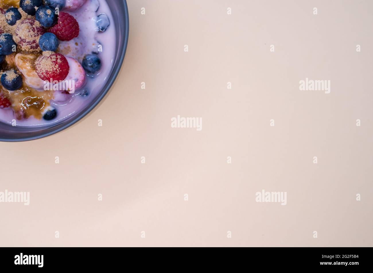 Top view of yogurt with raspberries, blueberries, and powder on bowl ...