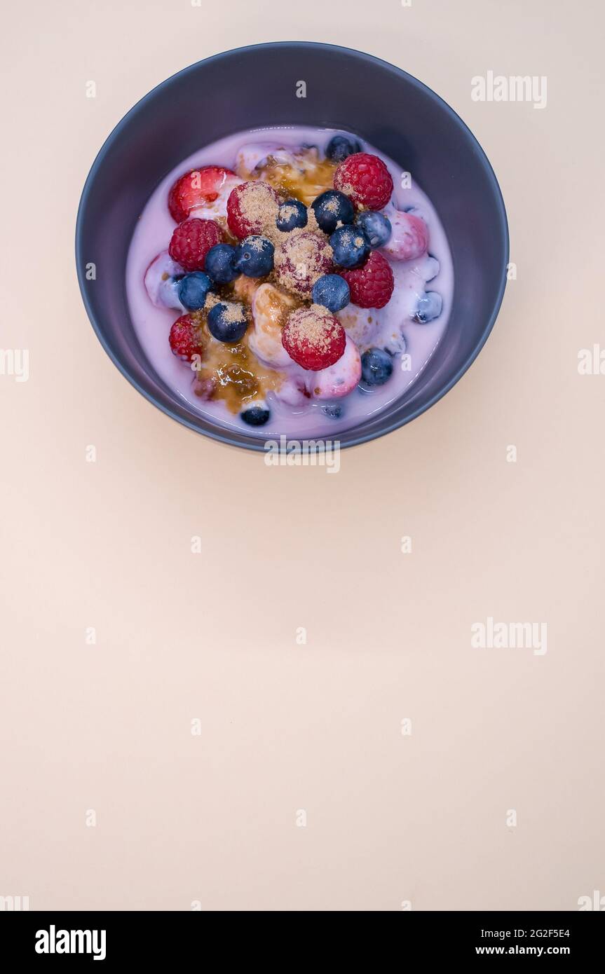 Bowl of yogurt with raspberries, blueberries, and powder isolated on a ...