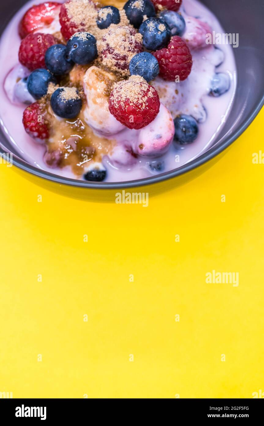 Bowl of yogurt with raspberries, blueberries, and powder isolated on ...