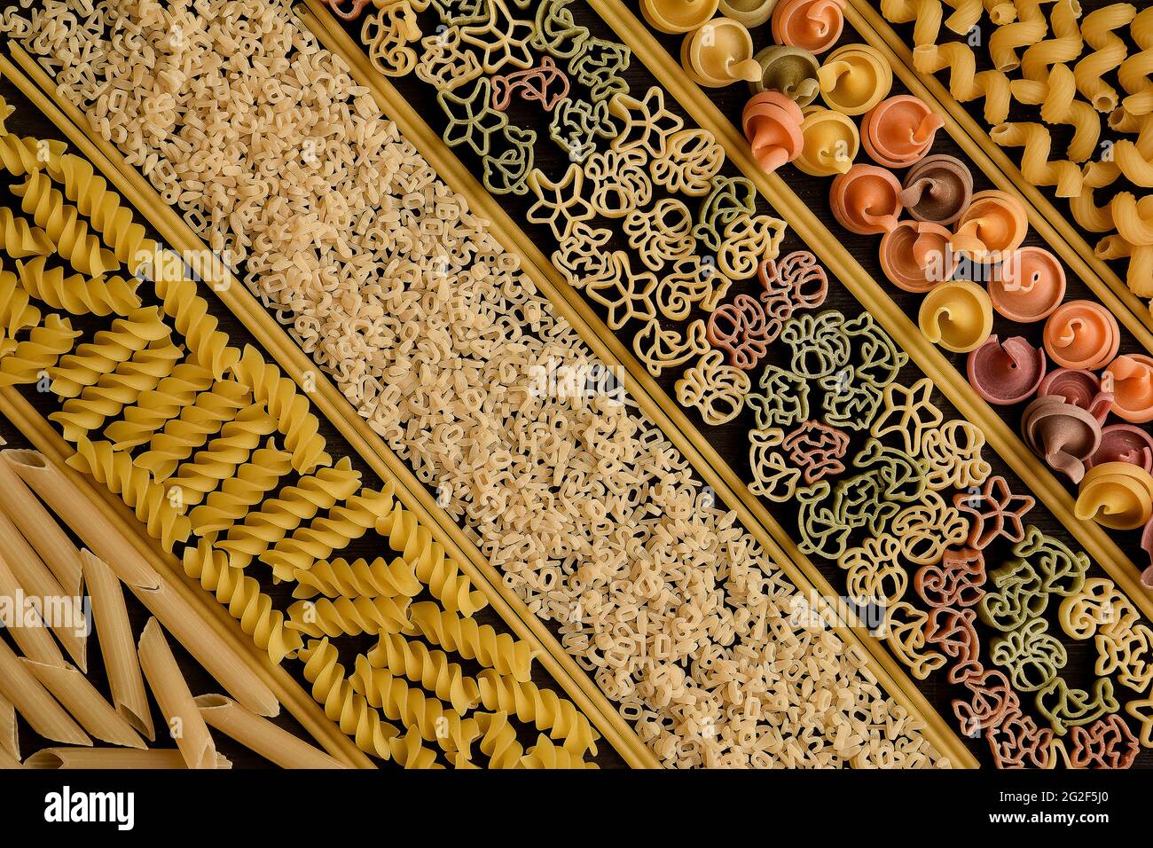 Lots of raw pasta of different types and colors, divided by spaghetti ...