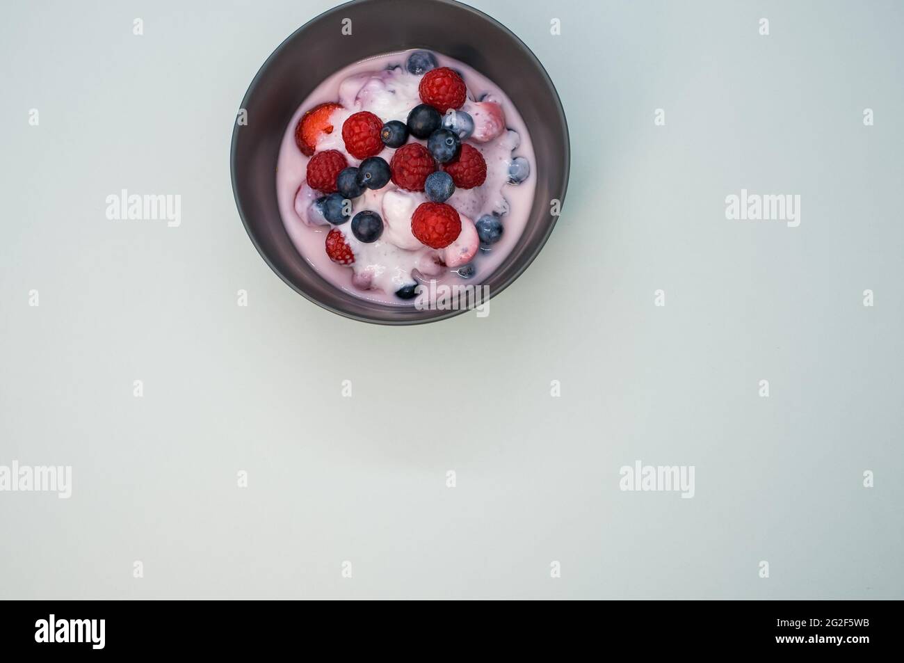 Top view of yogurt with raspberries and blueberries on a bowl isolated ...