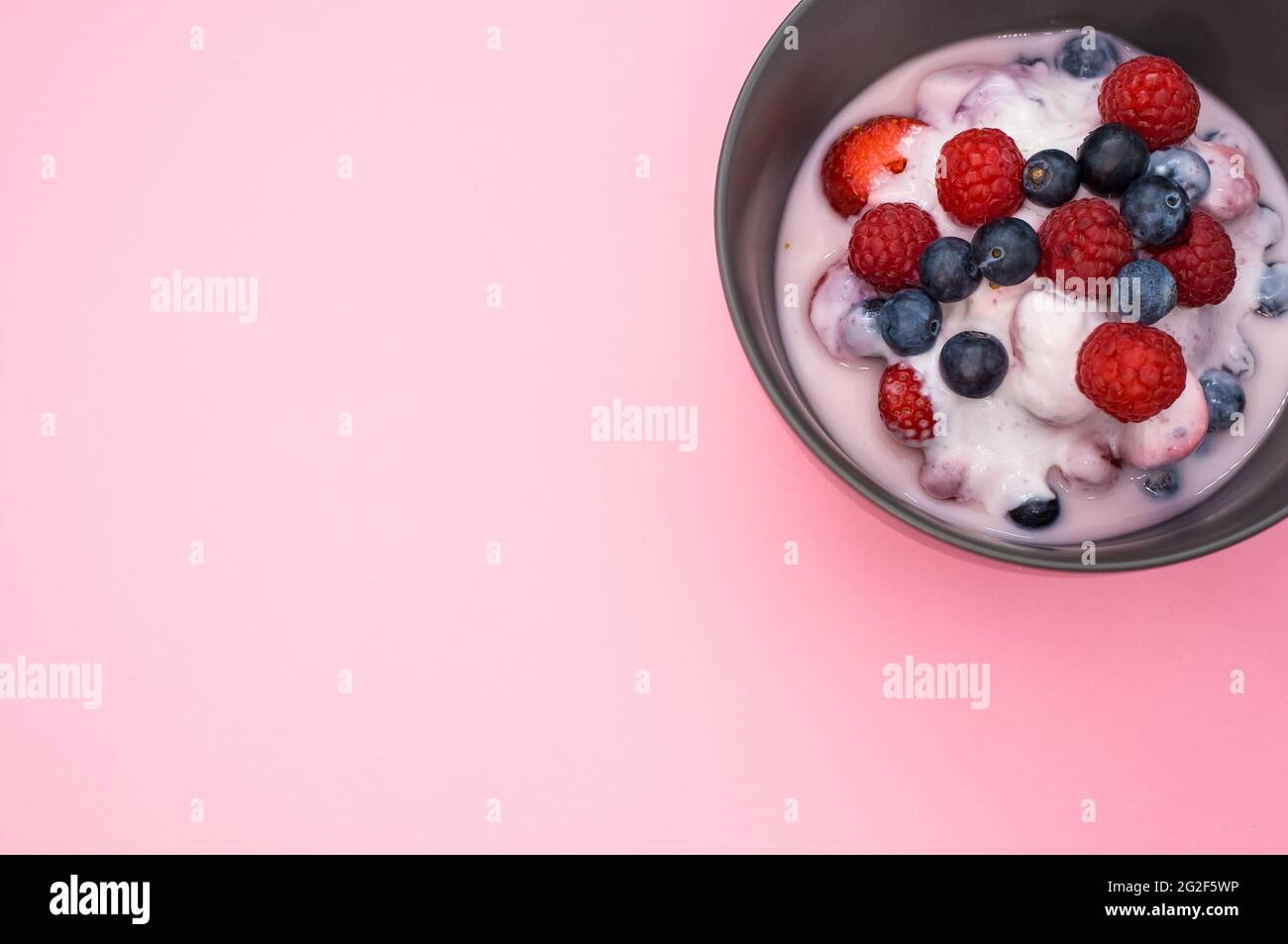 Top view of yogurt with fresh raspberries and blueberries on a bowl ...
